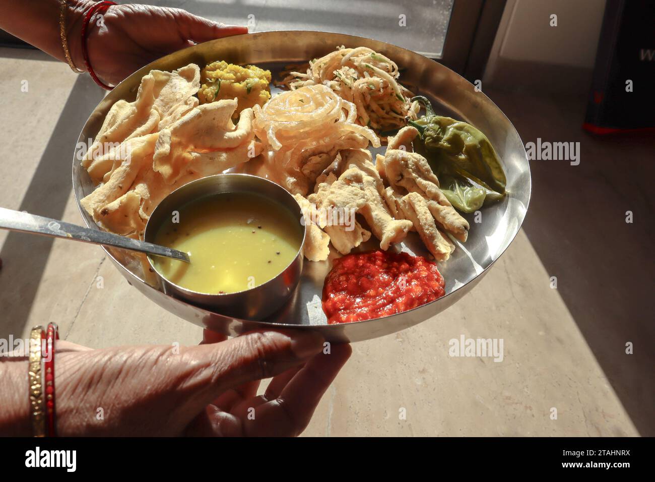 Female holding Gujarati special dish Fafda Jalebi with traitional ...