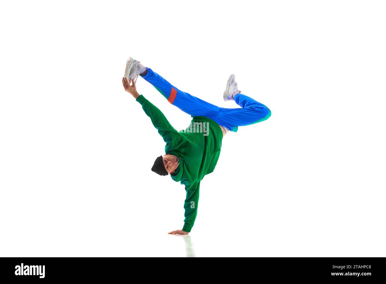Young flexible sportive man dancing breakdance in green and blue sport ...