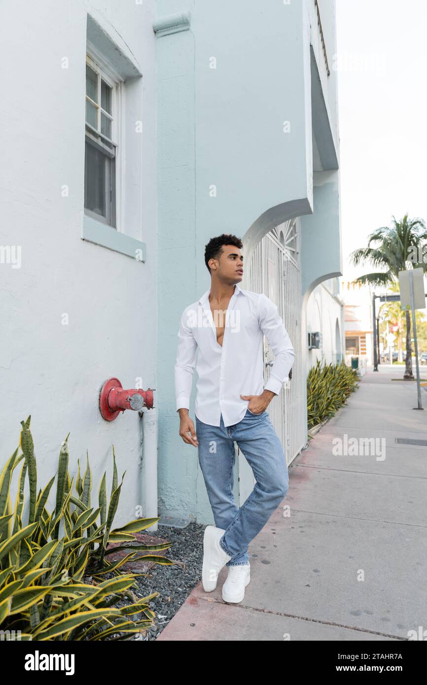 Full length of curly cuban man in stylish shirt and blue jeans posing ...