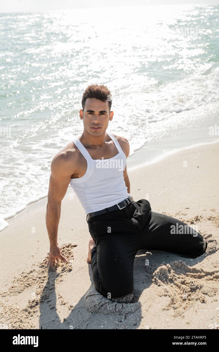 good looking and muscular cuban man posing and looking at camera near ...
