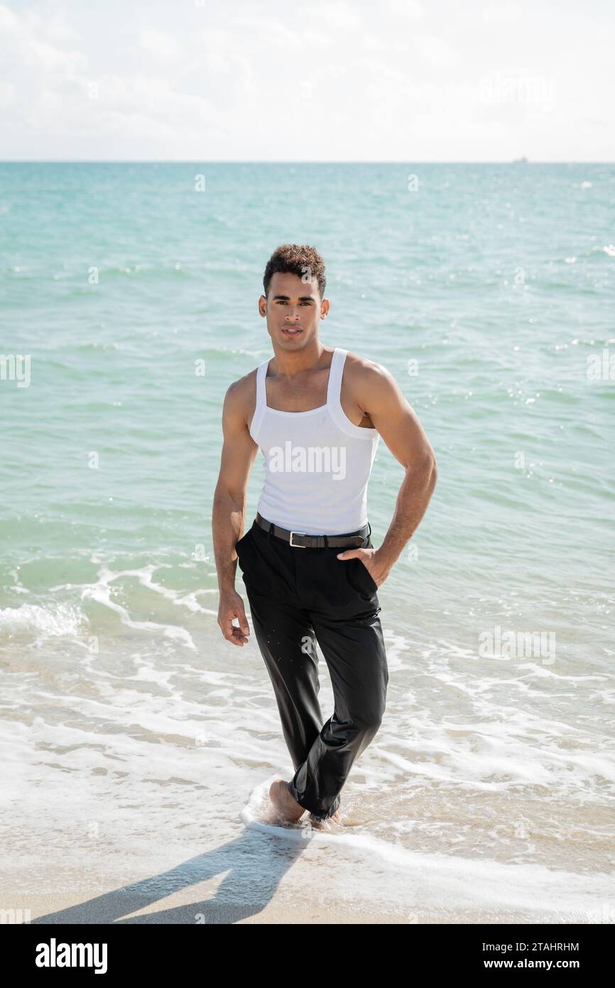 handsome muscular young Cuban man standing in ocean water in Miami ...