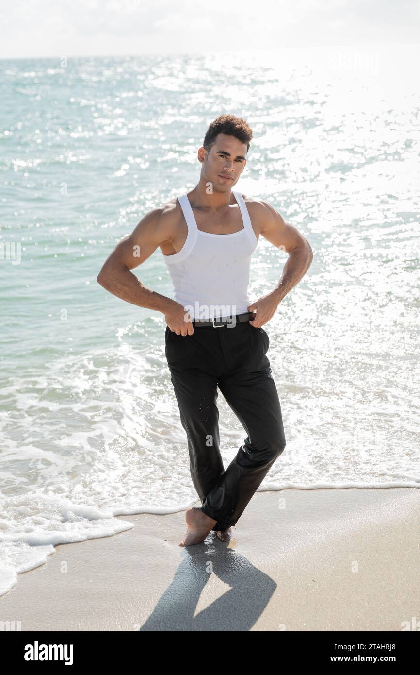 handsome and muscular Cuban man standing in ocean water in Miami South ...
