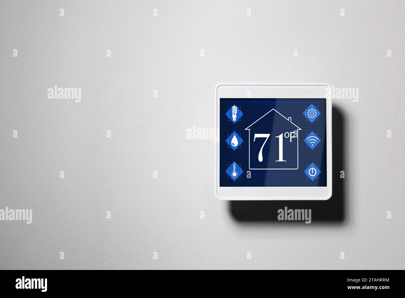 Thermostat displaying temperature in Fahrenheit scale and different icons. Smart home device on ...