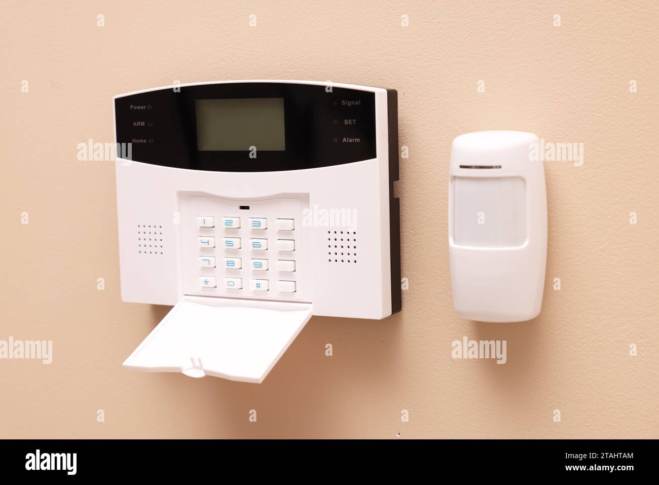 Home security alarm system on beige wall Stock Photo - Alamy