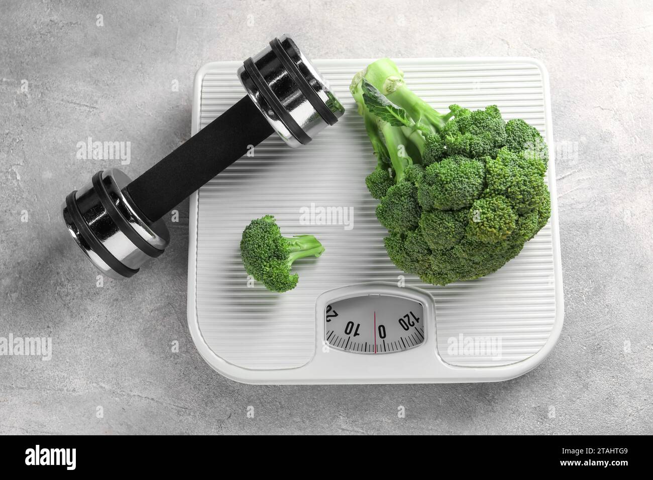 Healthy diet. Scale, broccoli and dumbbell on grey table, top view ...