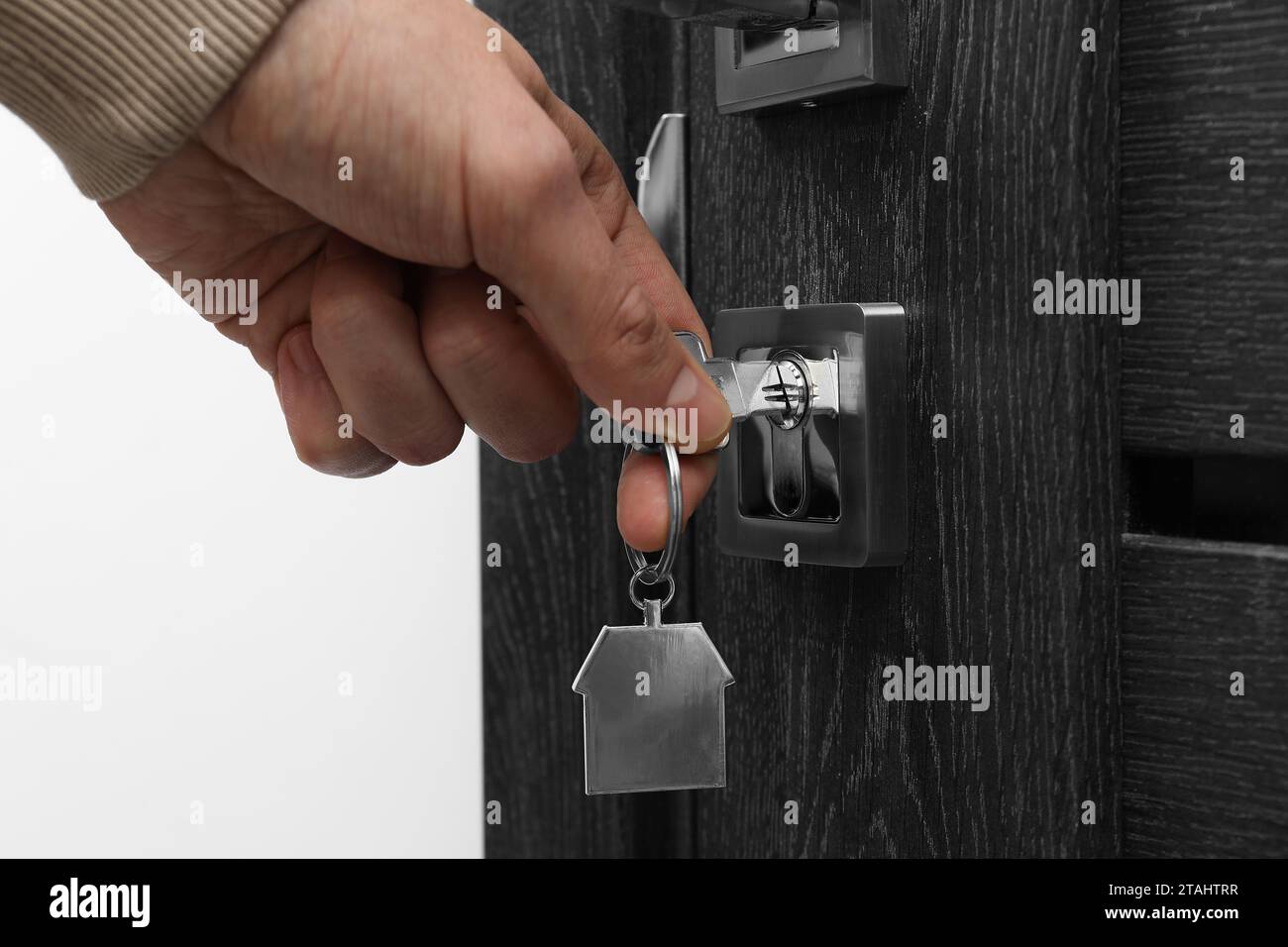 Man unlocking door with key, closeup view Stock Photo - Alamy