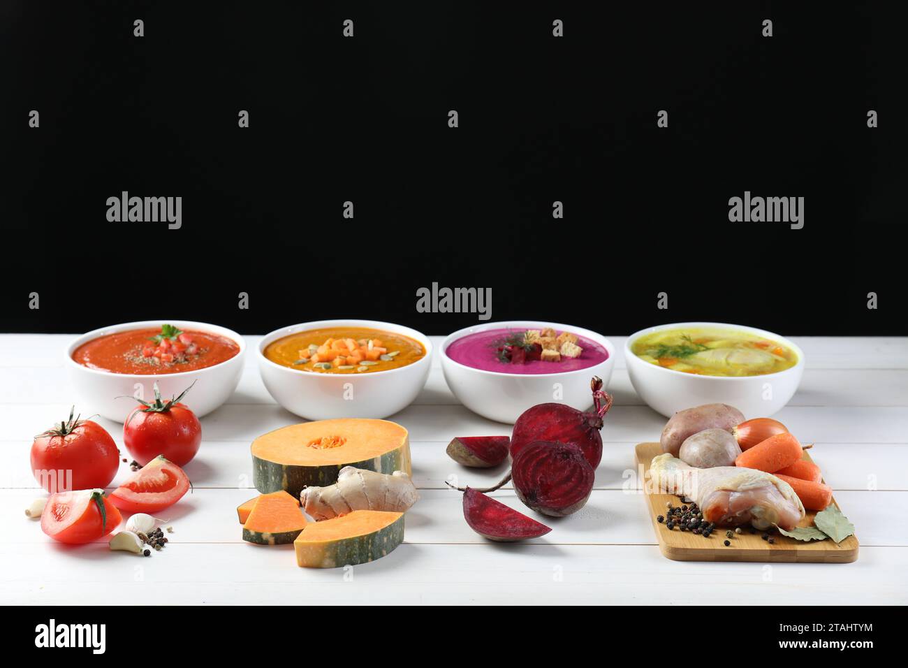 Tasty broth, different cream soups in bowls and ingredients on white ...