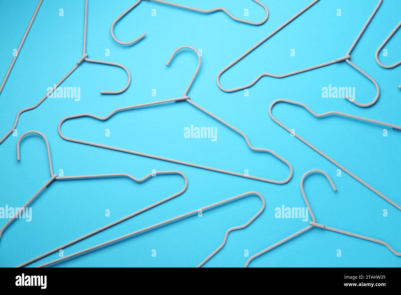 Hangers on light blue background, flat lay Stock Photo - Alamy