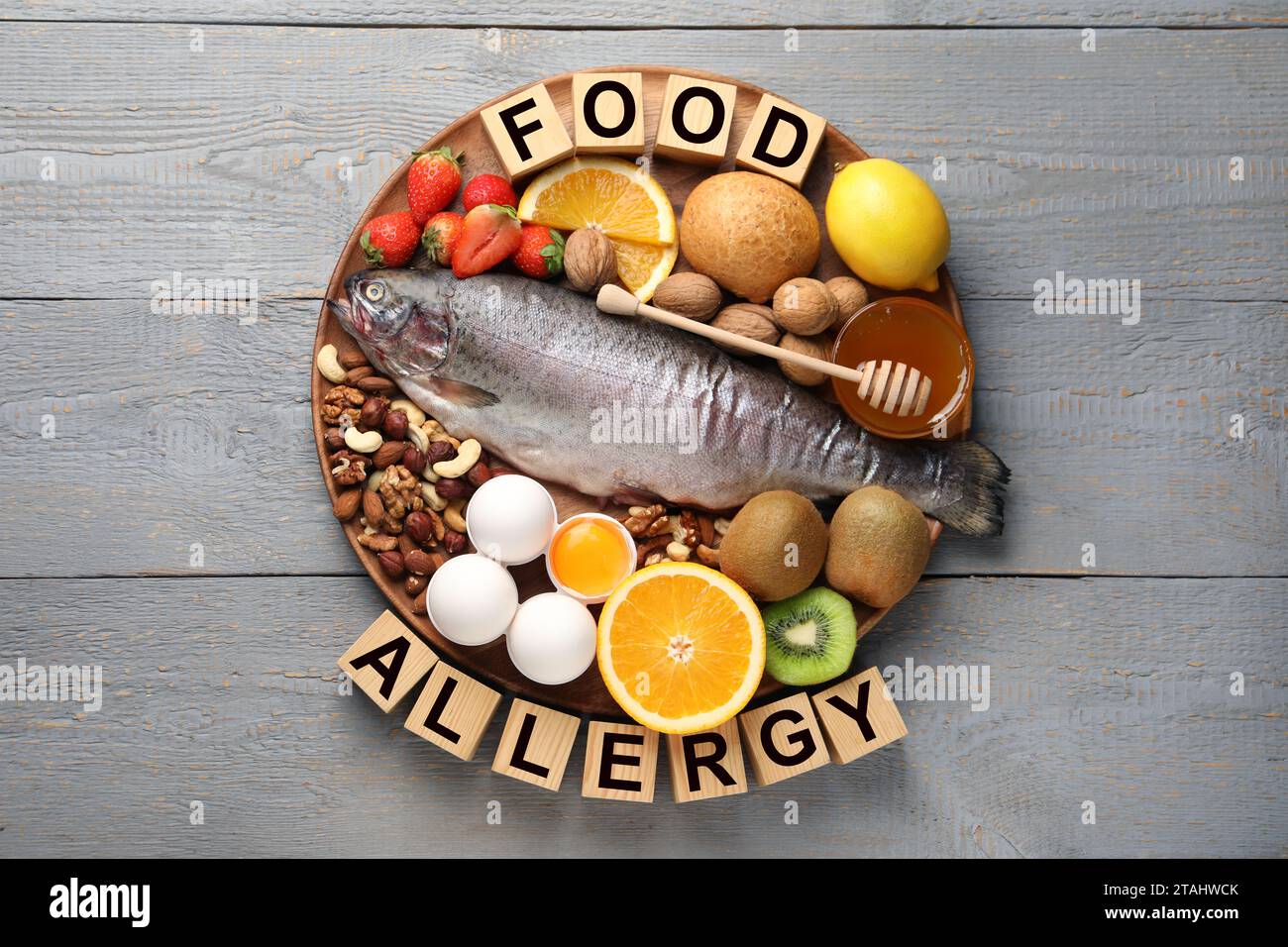 Food allergy. Different fresh products and cubes on grey wooden table ...
