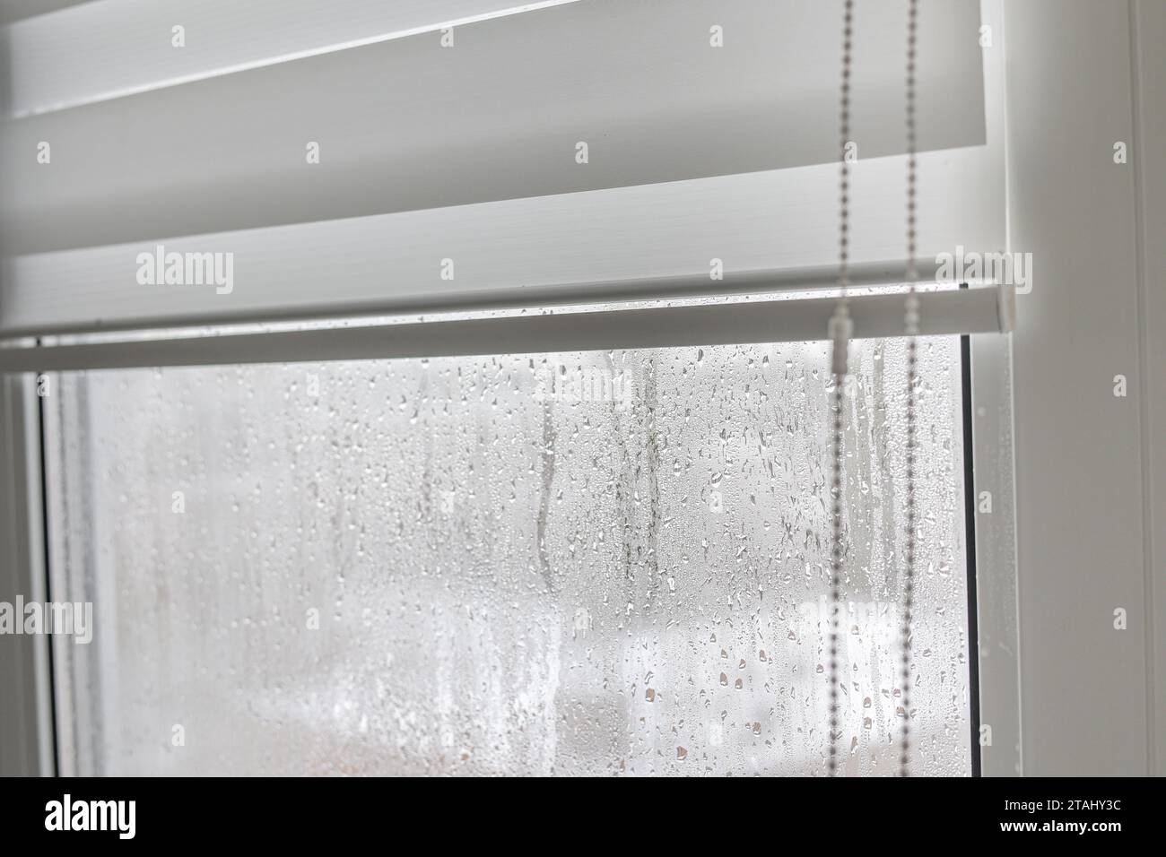 Water droplets condensation on white metal-plastic frame of window ...