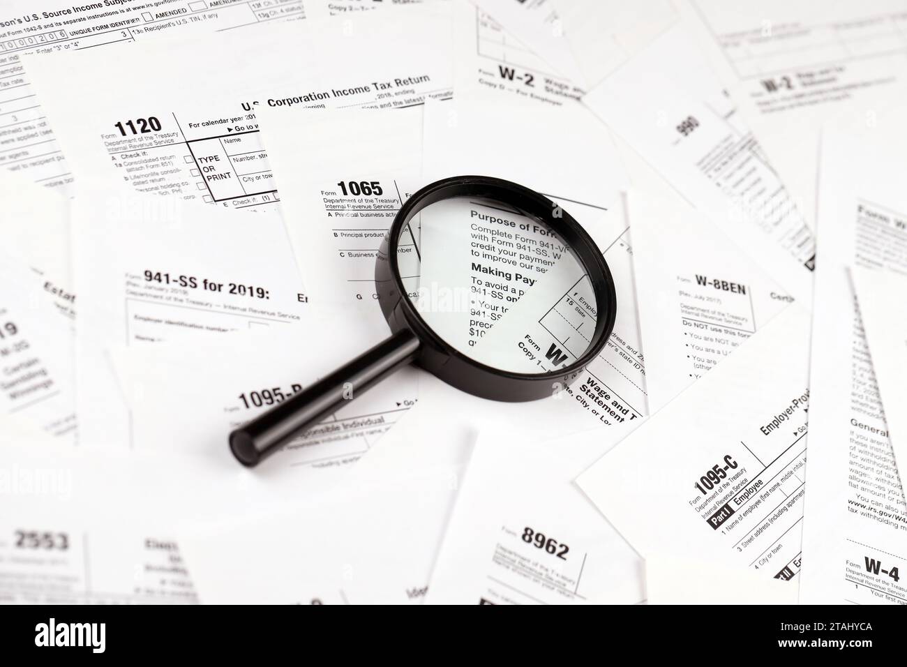 Magnifying glass lying over heap of paper documents. Investigation and ...