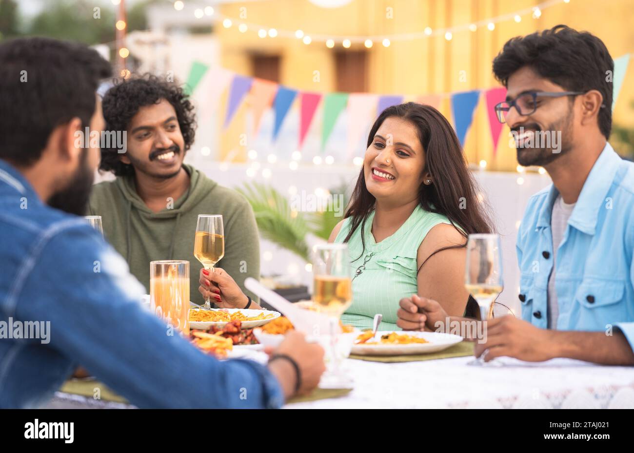 Group of young friends laughing together while having evening treat ...