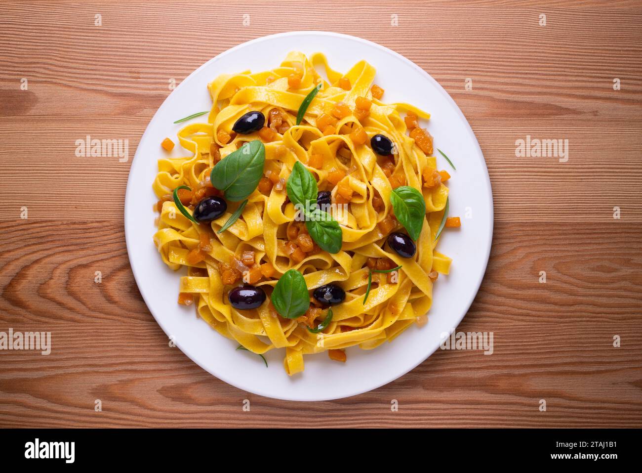 Pasta ribbons with sautéed pumpkin and black olives Stock Photo - Alamy
