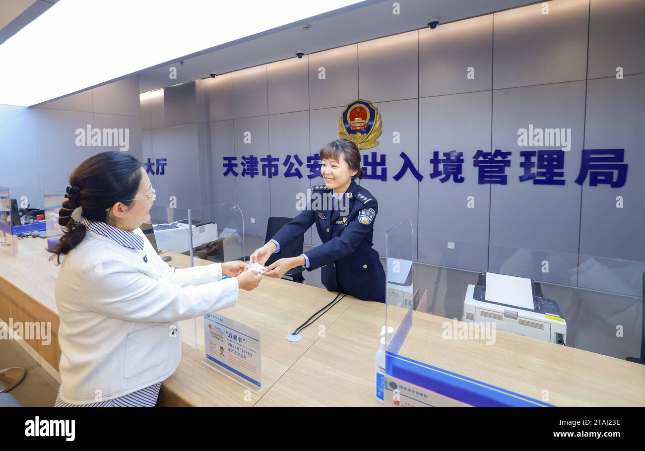 (231201) -- TIANJIN, Dec. 1, 2023 (Xinhua) -- A police officer hands a ...