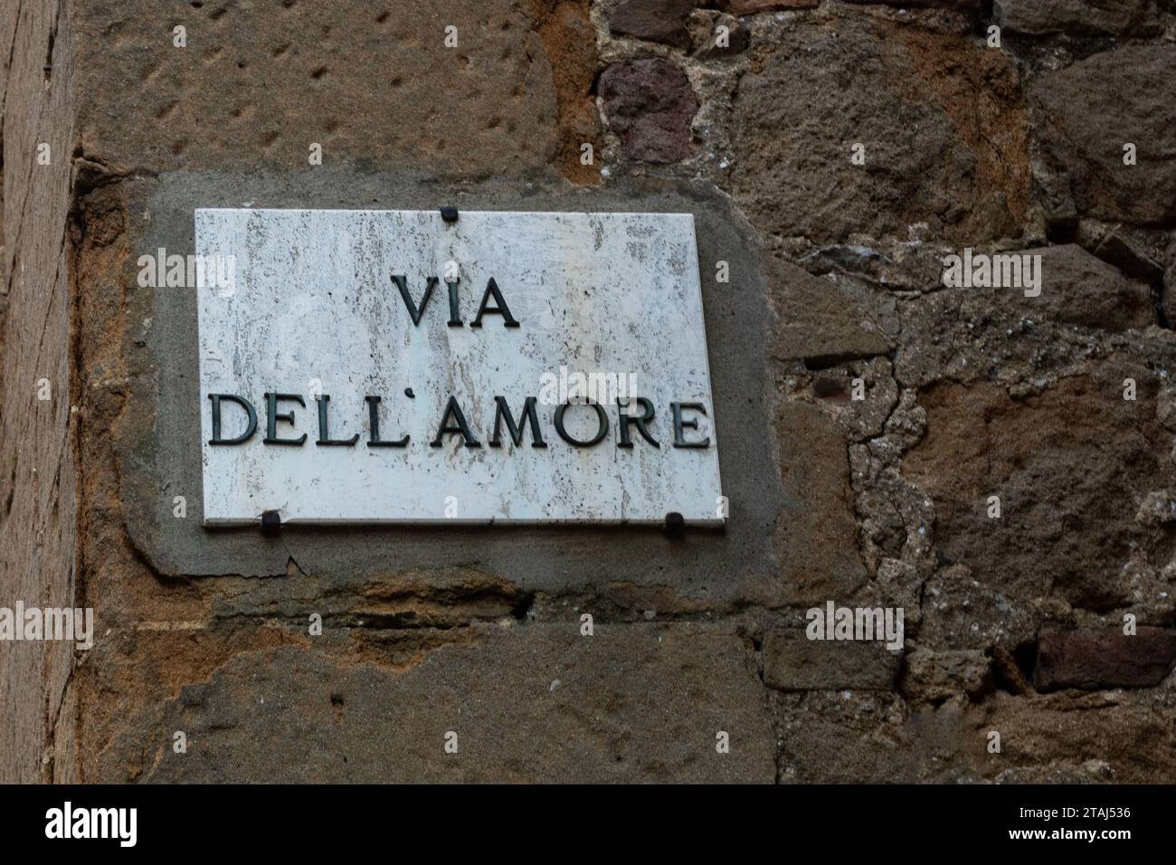 A street name sign reading Via Dell'Amore - The street of love - and ...