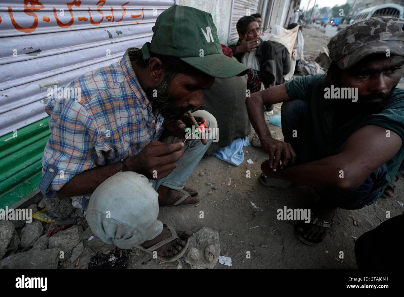 Pakistani drug addicts smoke heroin on a roadside in Karachi, Pakistan ...