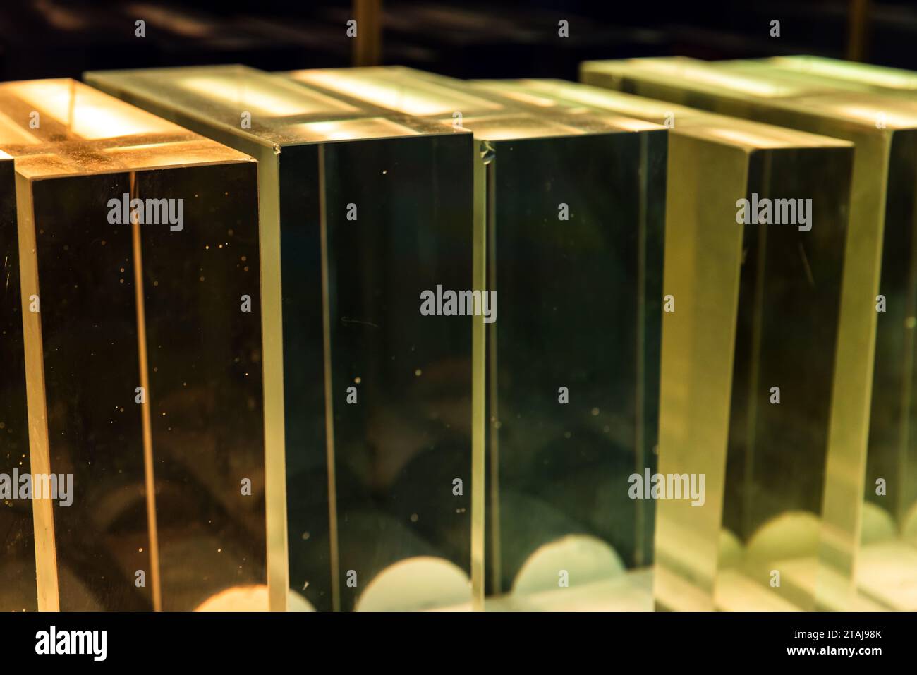 Solid glass blocks stand in a row under colorful illumination, abstract ...