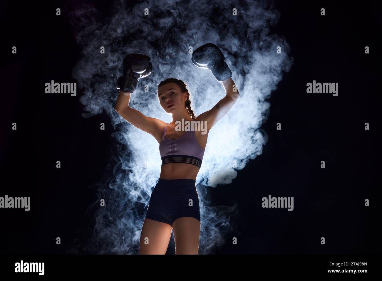 Powerful boxer girl in shorts and gloves vining pose, symbolizing ...