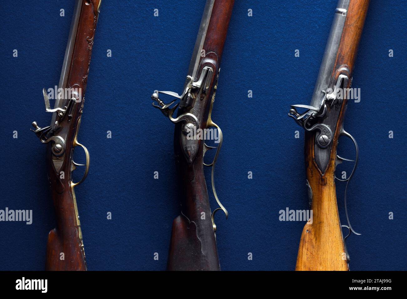 Flintlocks of 18th-century rifles over deep blue velvet background ...