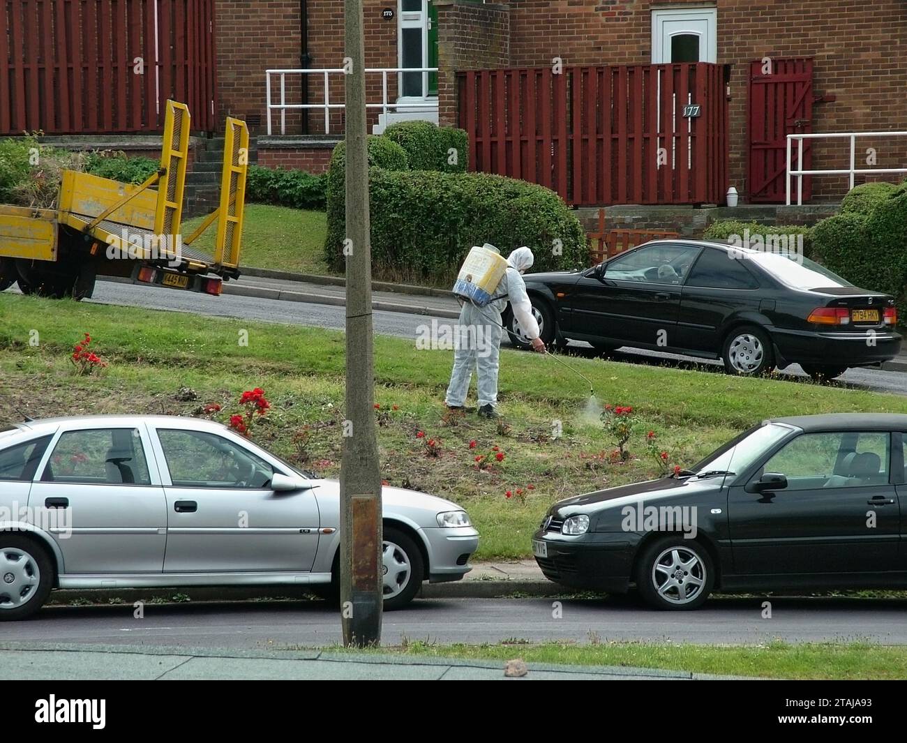 Worker dressed in protective suit Hazmat spraying weed killing ...