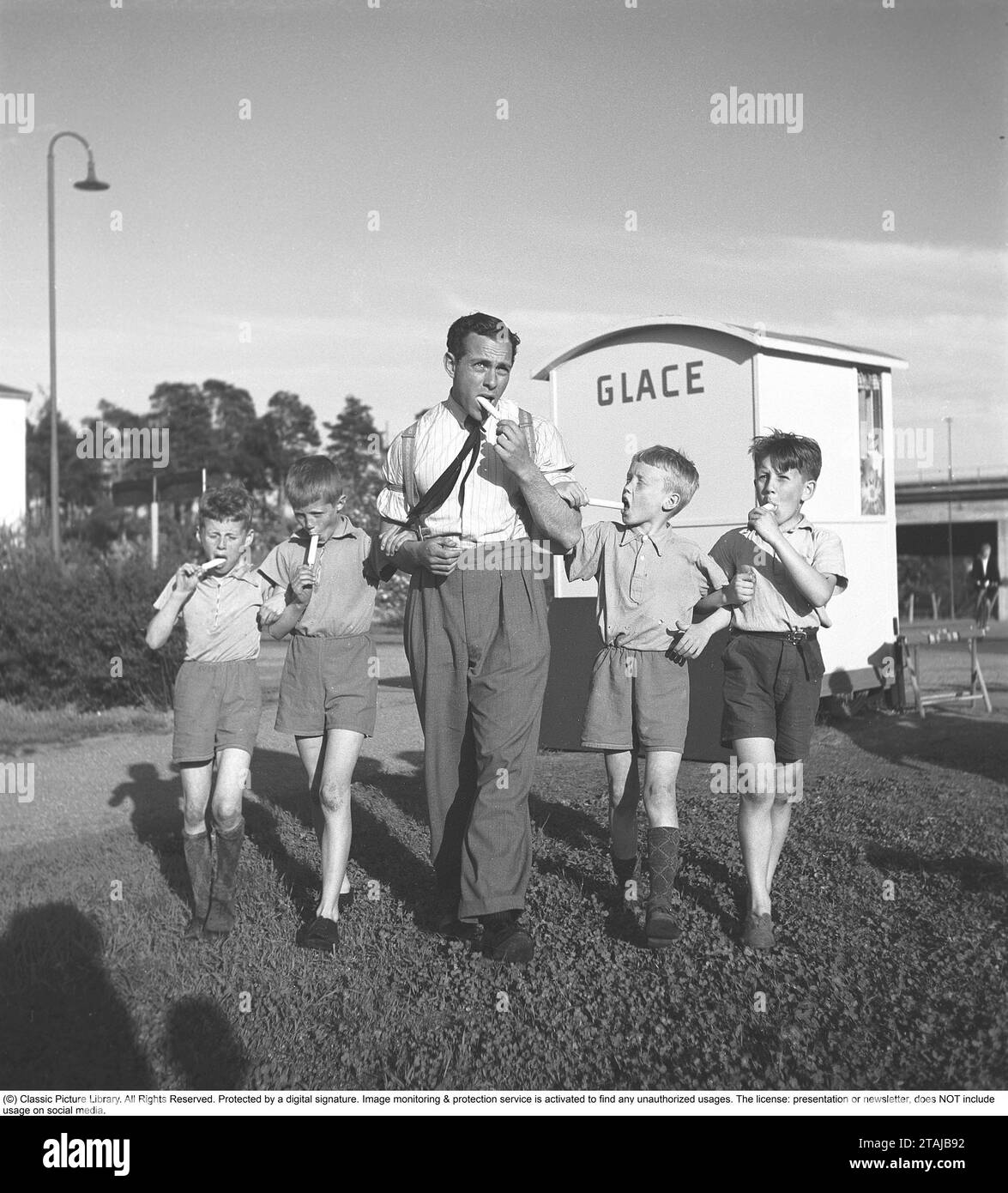 Ice cream in the 1940s. A man with four boys eating ice cream they ...