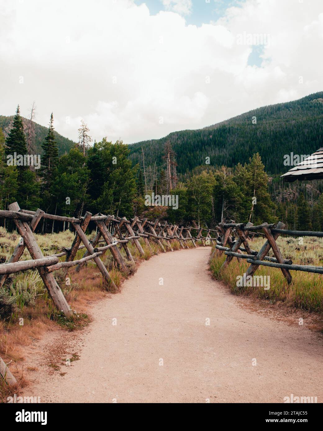 A fenced pathway in a village in green mountains on a cloudy day Stock ...