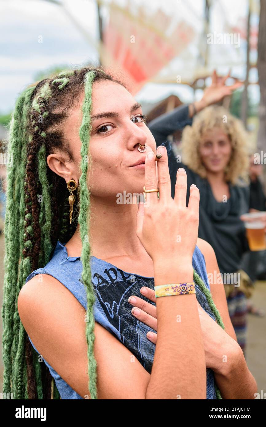 A young female with dreadlocks and facial piercings posing for the ...