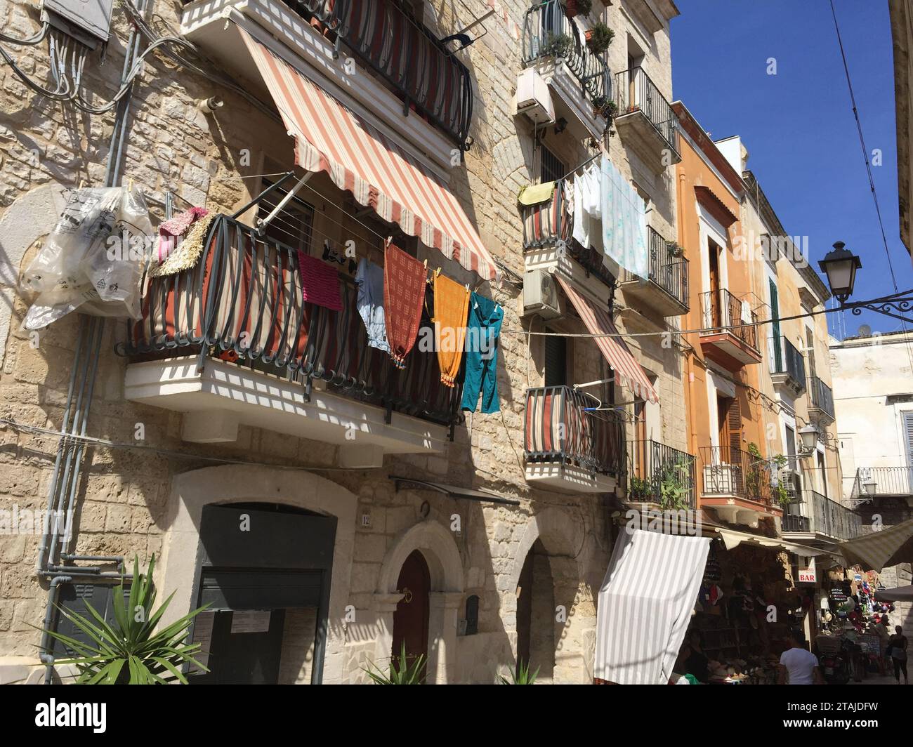 Old Italian house facades in Bari with balconies, striped awnings, wash ...