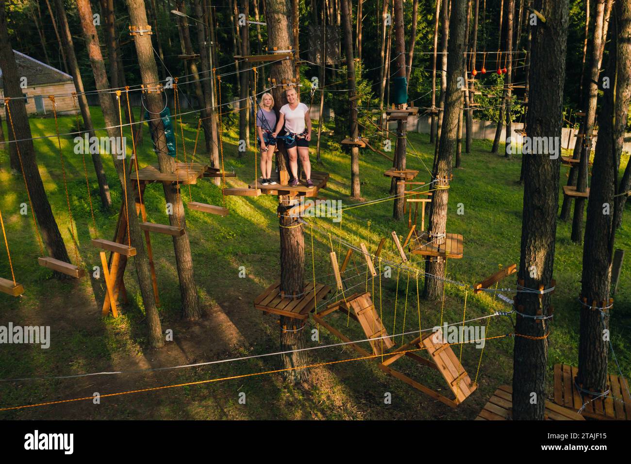 A girl passes an obstacle in a rope town. A girl in a forest rope park ...