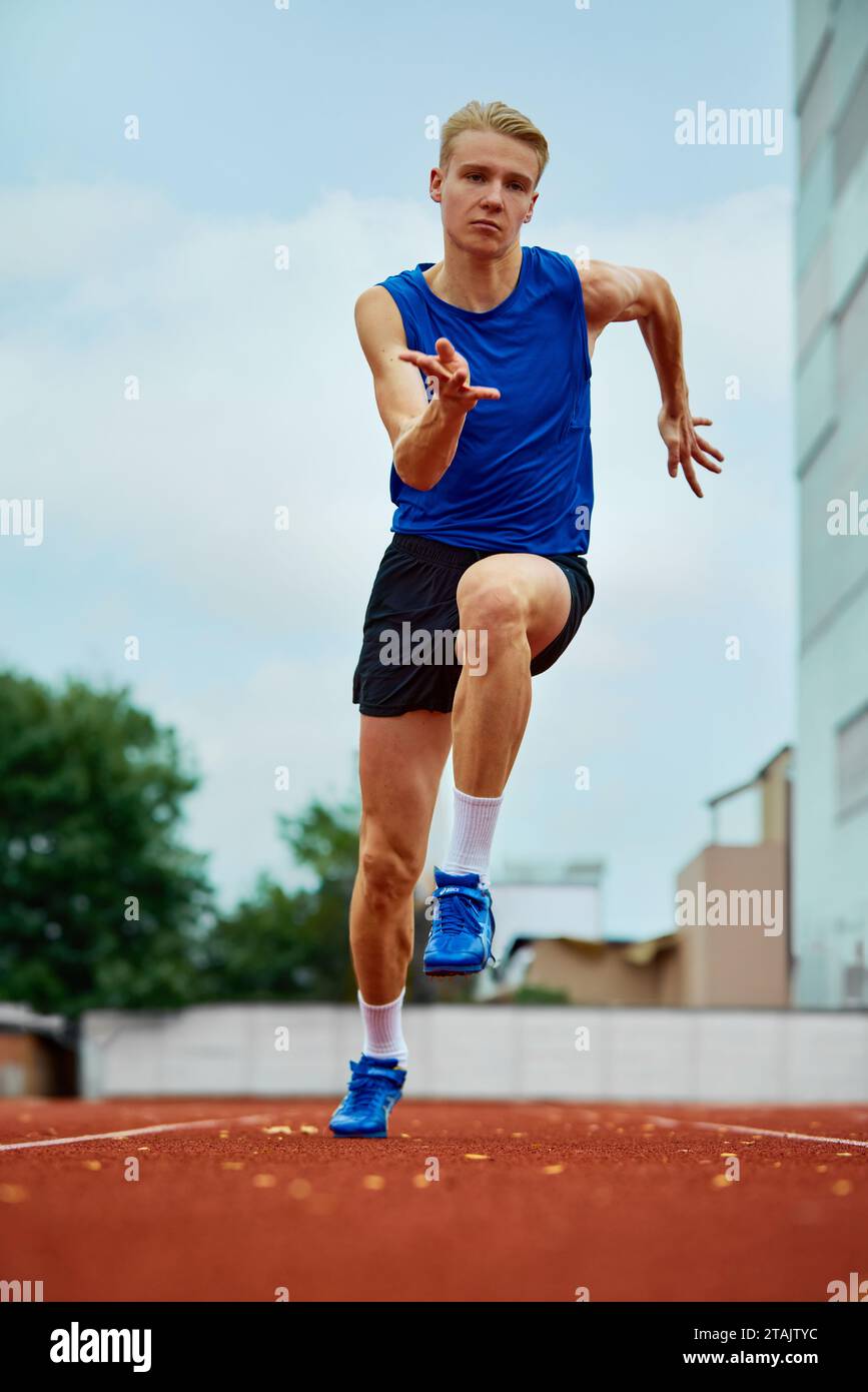 Energetic athlete dashing with determination. Full length portrait of ...