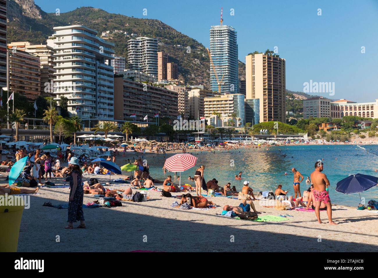 Bathers & other people enjoy beautiful Larvotto Beach & swimming in the ...