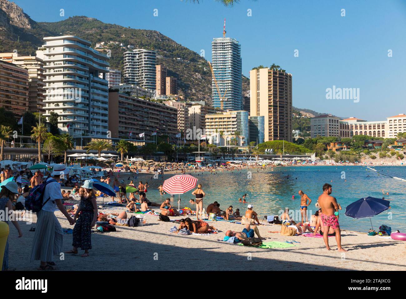 Bathers & other people enjoy beautiful Larvotto Beach & swimming in the ...