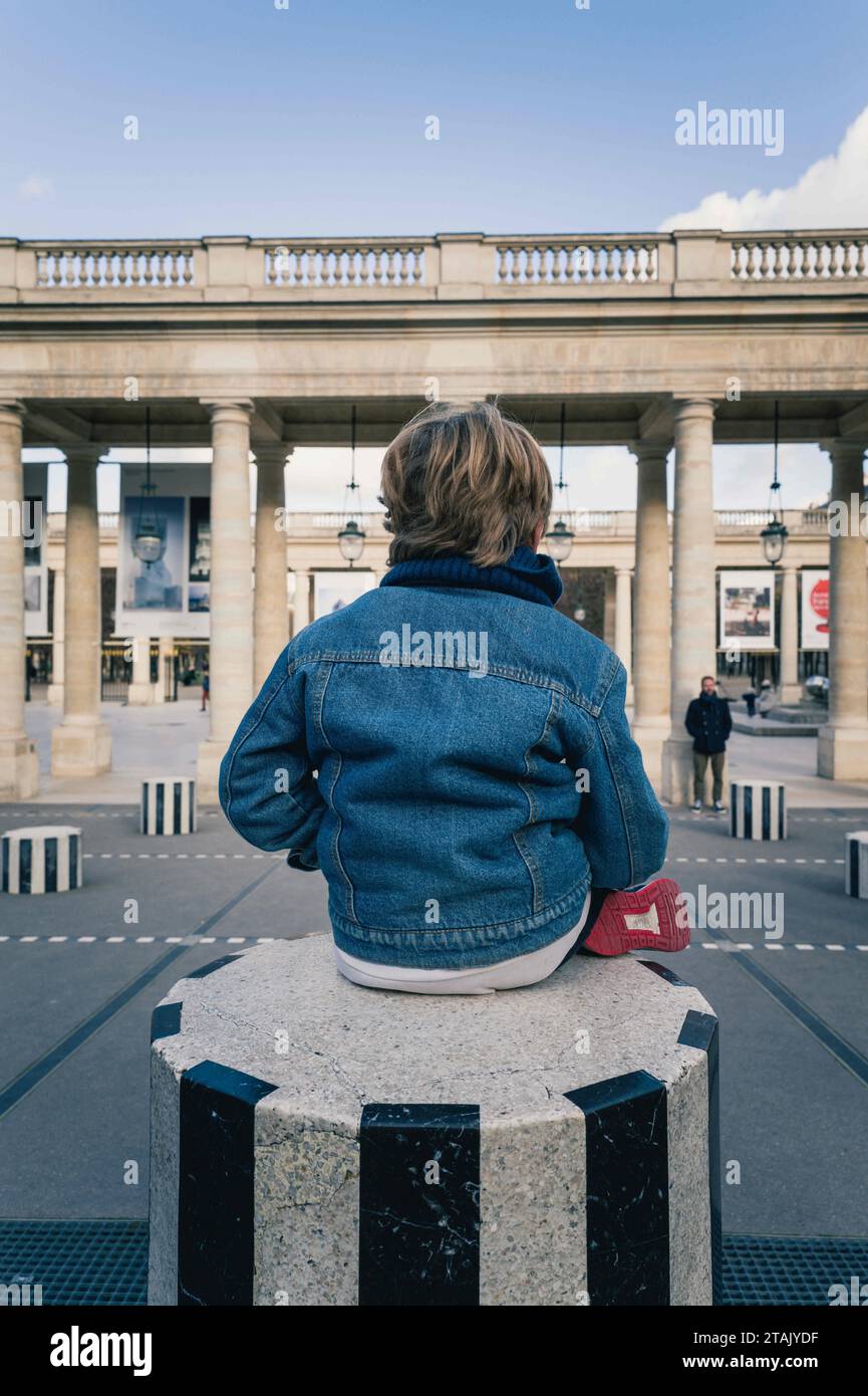 Paris, France. 24th Nov, 2023. A young boy sitting on a Buren column in ...