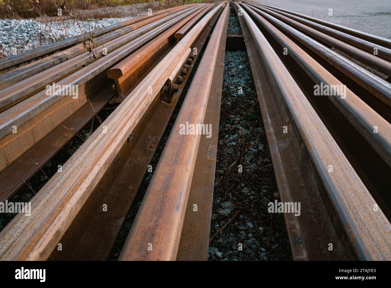 Many used rusty rails of different length stored at a side of railway ...