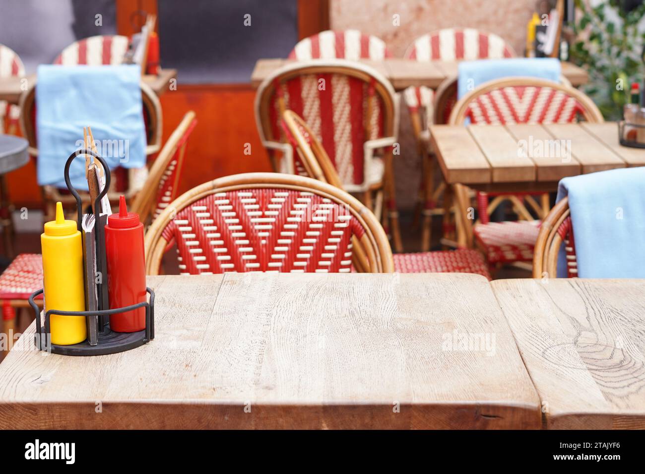 Outdoor empty restaurant terrace with wooden tables and chairs in ...