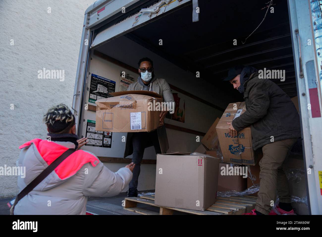 Pastor Torrey Barrett, center, gets help from migrants to unload ...