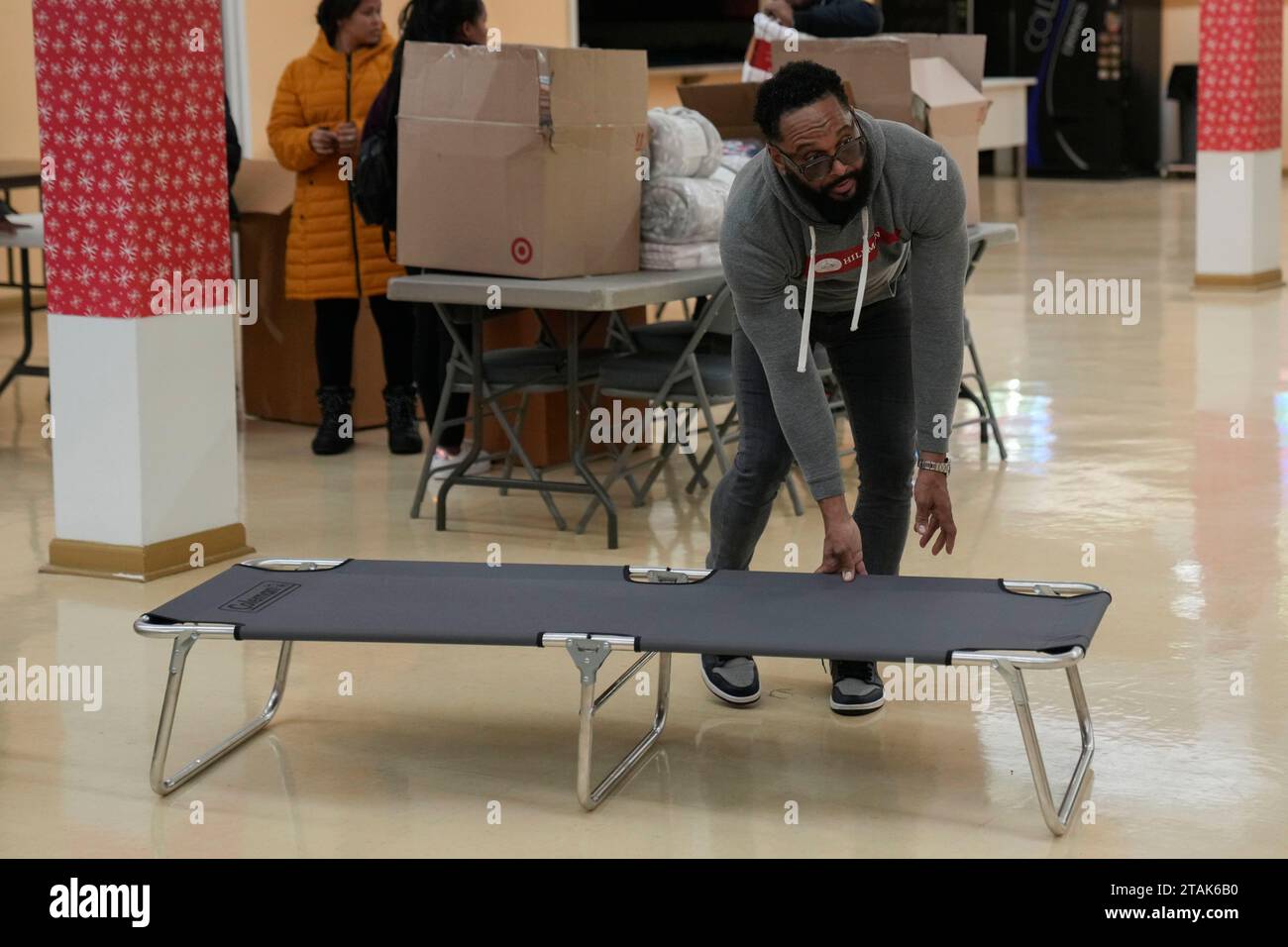 Pastor Torrey Barrett sets up a cot in the Chicago City Life Center ...