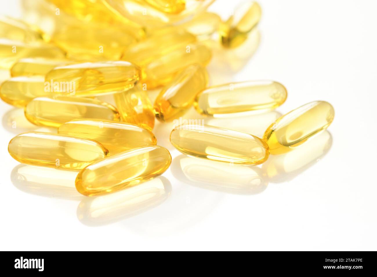 Capsules. Yellow pills isolated on white. Close up capsules with ...