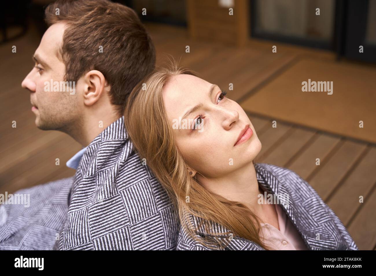 Thoughtful man and his beautiful wife sitting on doorstep Stock Photo ...