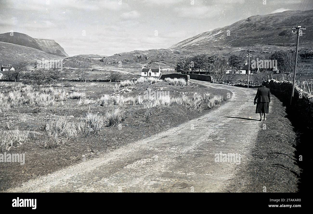 1950s, historical, a lady standing outside on a rural lane at Assynt ...