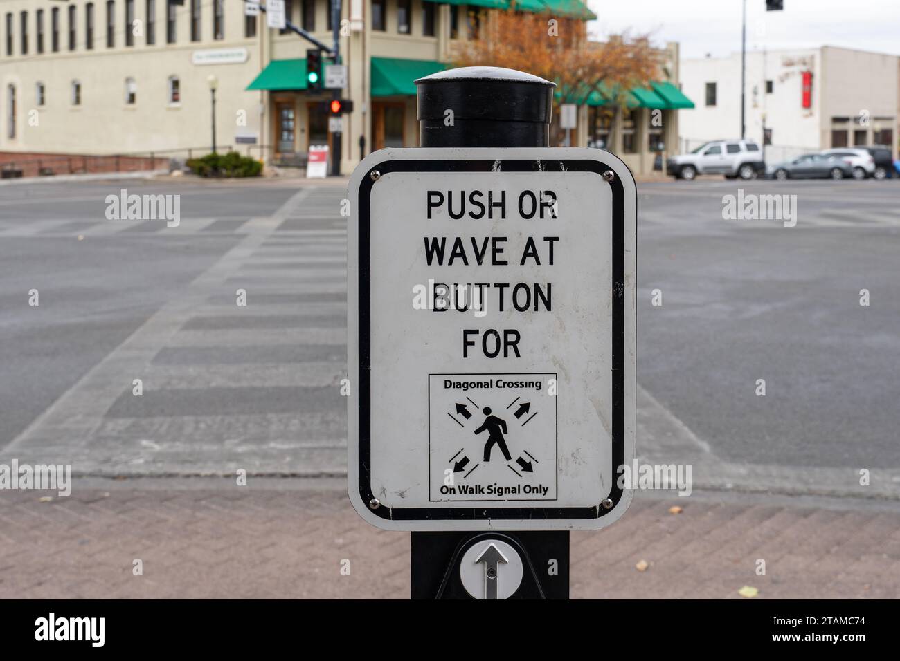 Diagonal crosswalk sign and button. Pedestrians may cross the street ...