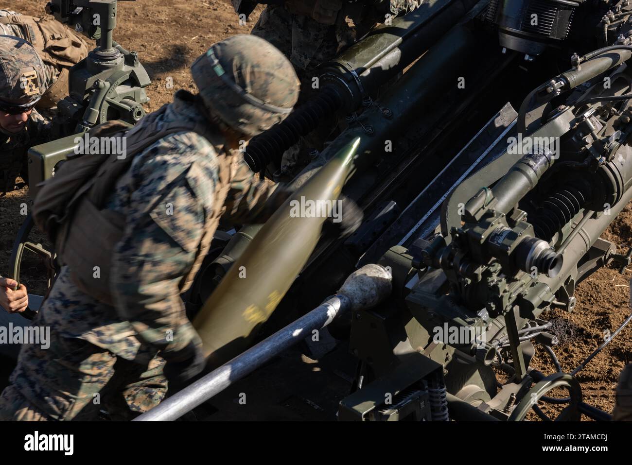 U.S. Marine Corps Lance Cpl. Rolando Romero loads high explosive rounds ...