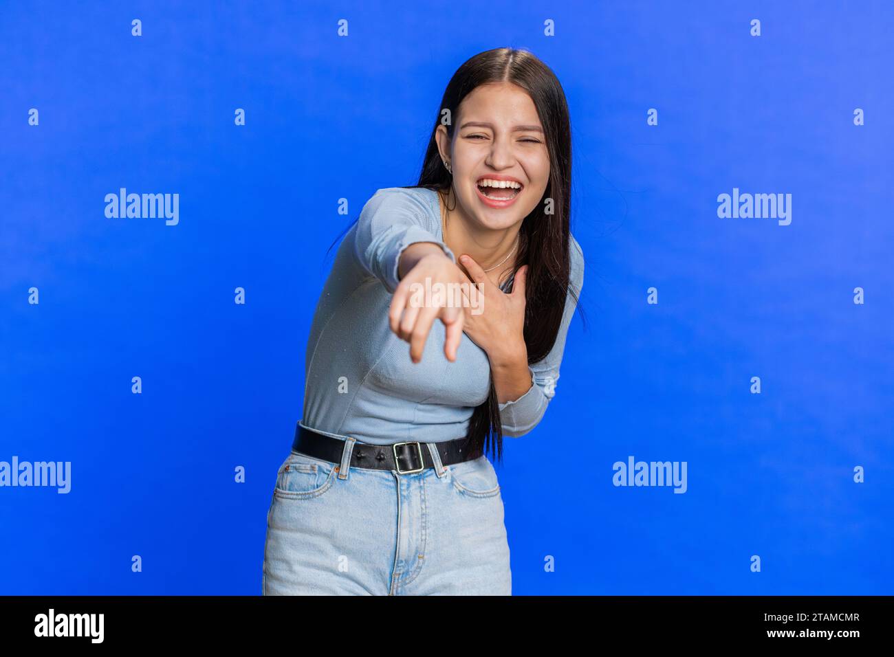 Amused lovely woman pointing finger to camera, laughing out loud ...