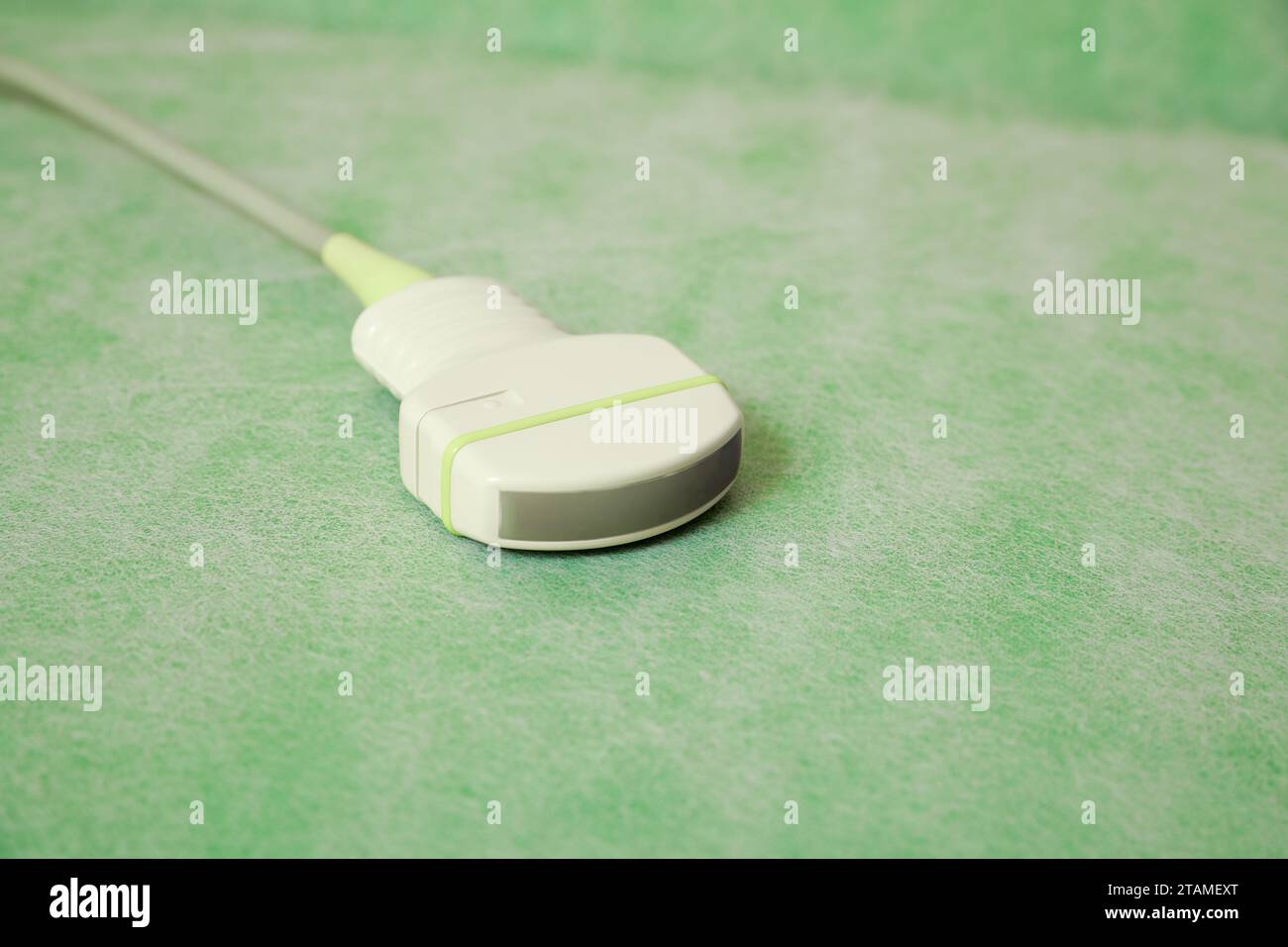 Ultrasonic transducer on green examination table, closeup. Ultrasound ...