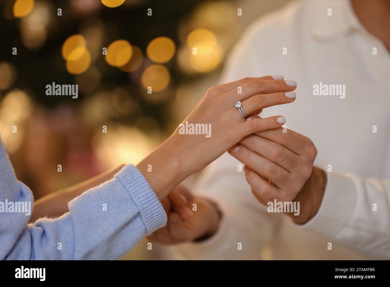 Making proposal. Man putting engagement ring on his girlfriend's finger ...