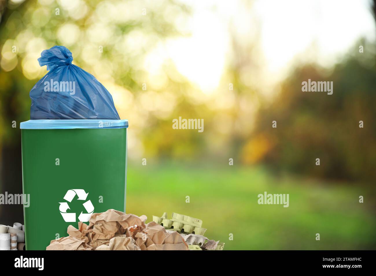 Waste bin with plastic bag full of garbage surrounded by garbage ...