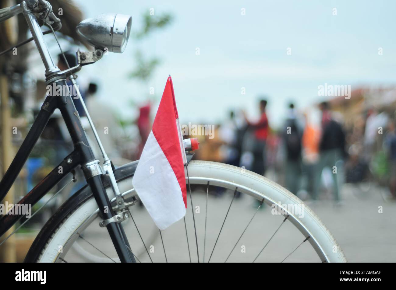 The front of the antique bicycle has an Indonesian flag with a blurred ...