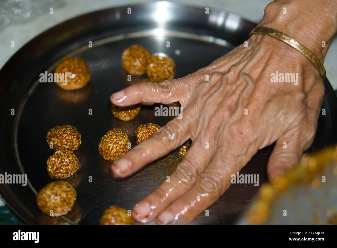 making of jaggery and seasame seed delicacy called tiler naru by hand ...