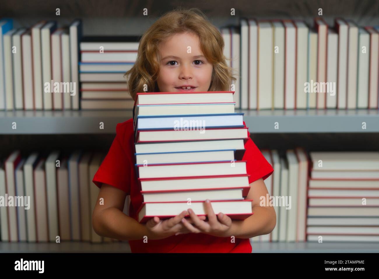 Smart pupil. Little student on school library. Kid reading book at ...