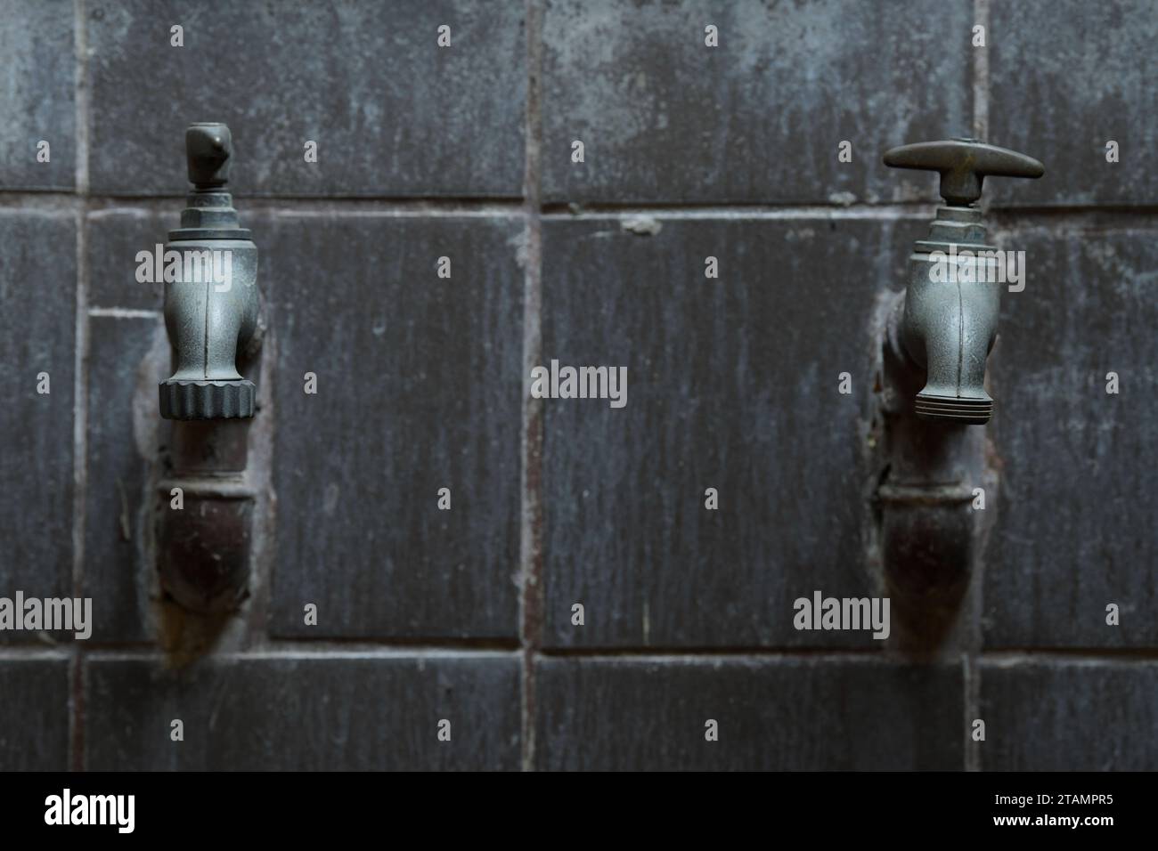 Dry faucet on tile wall, two water taps, drought concept, background ...